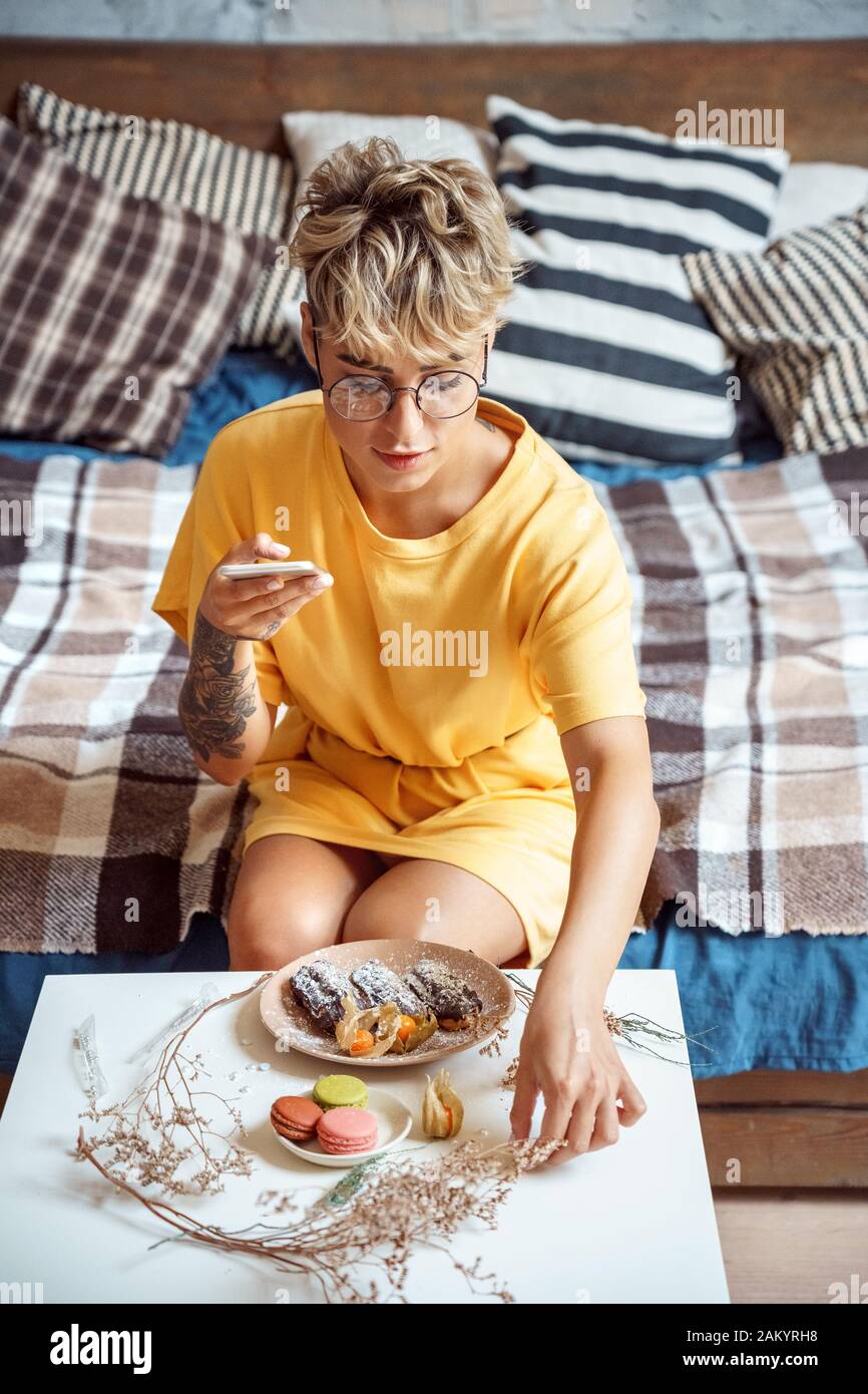 Young adult blogger making photo with food on modern smartphone Stock ...