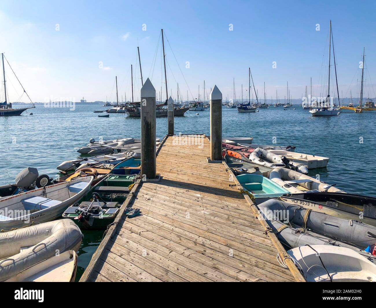 Little wood pier with small abandoned boat and Sailing boat on the ...
