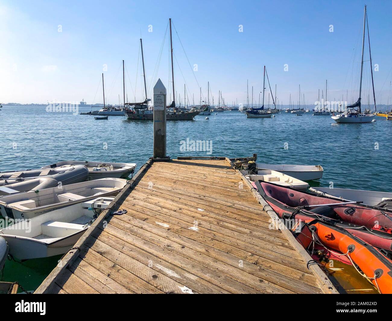 Little wood pier with small abandoned boat and Sailing boat on the ...