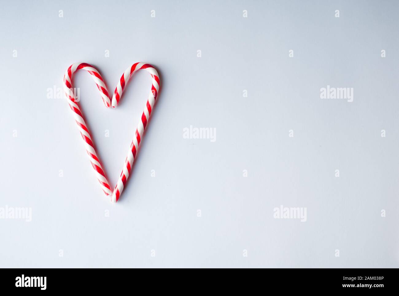 Candy canes arranged in a heart shape on a plain white background Stock ...