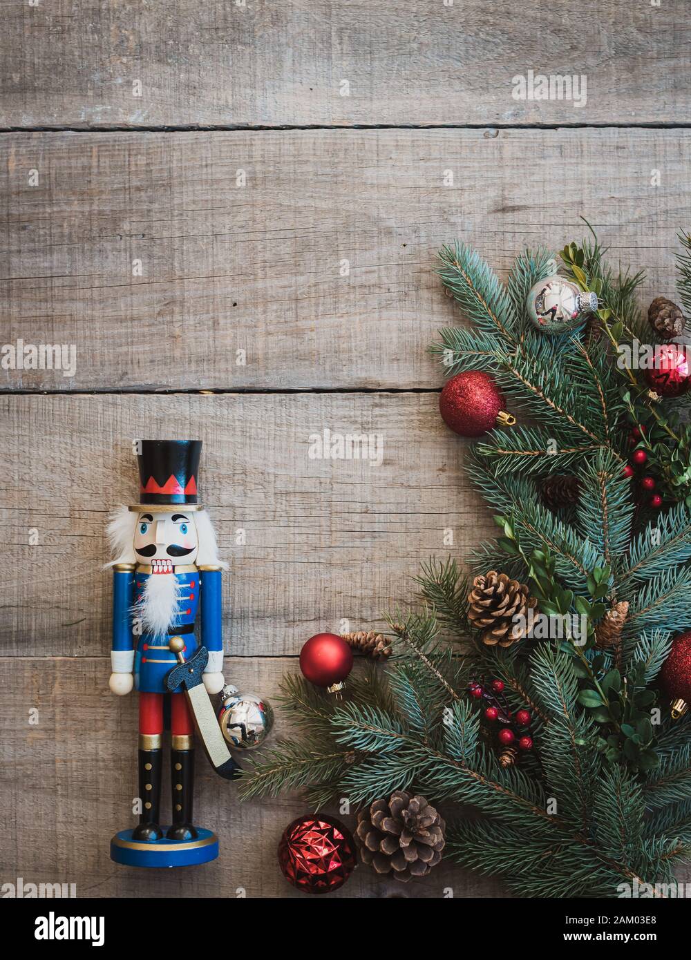 christmas greenery, decorations and nutcracker against wood backdrop ...