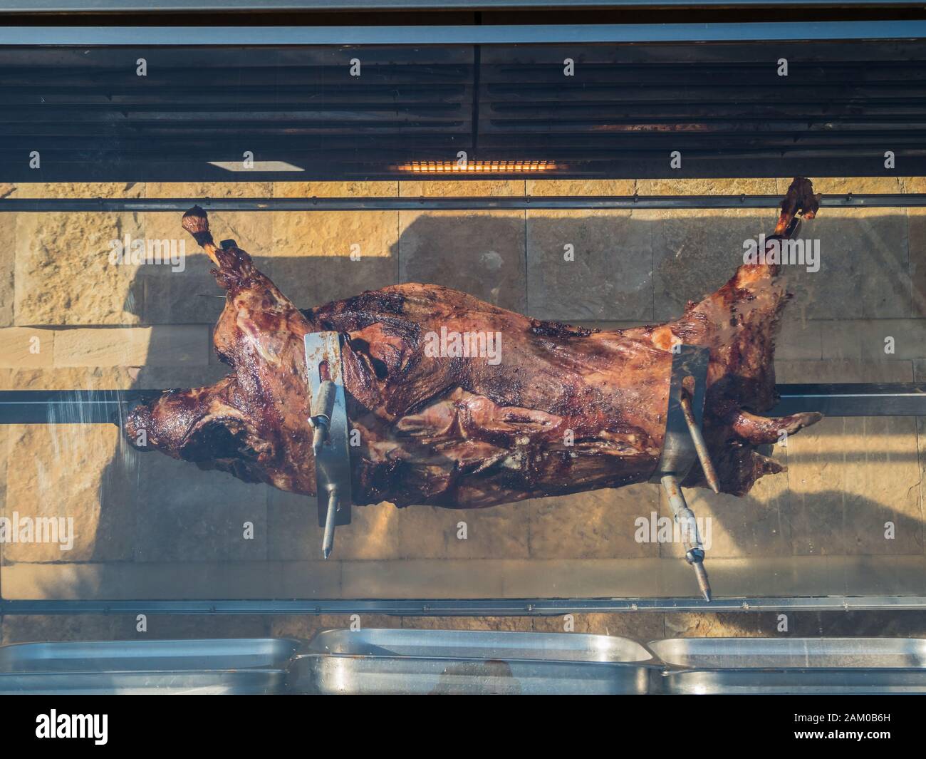 Pig roasting on electric skewer in Sochi day sun Stock Photo - Alamy