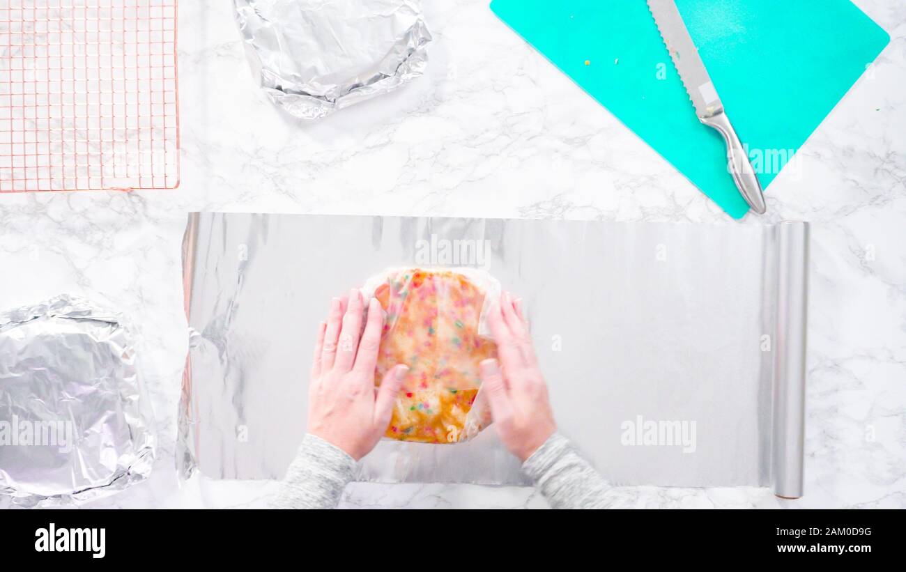 Flat lay. Step by step. Wrapping freshly baked funfetti cake into ...