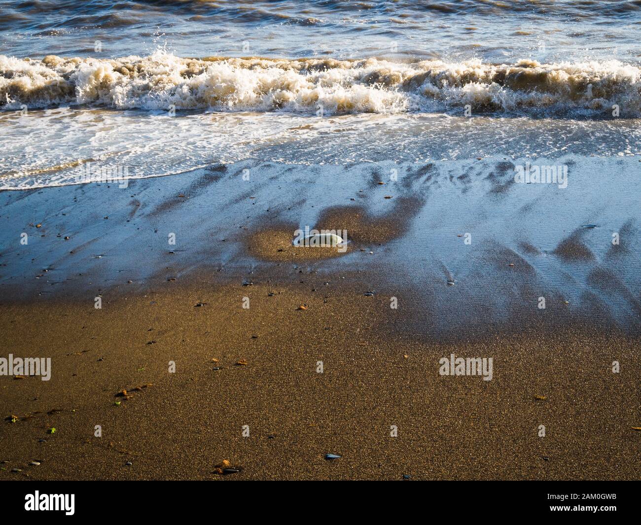 The stone sinks in the sand from the sea waves Stock Photo - Alamy
