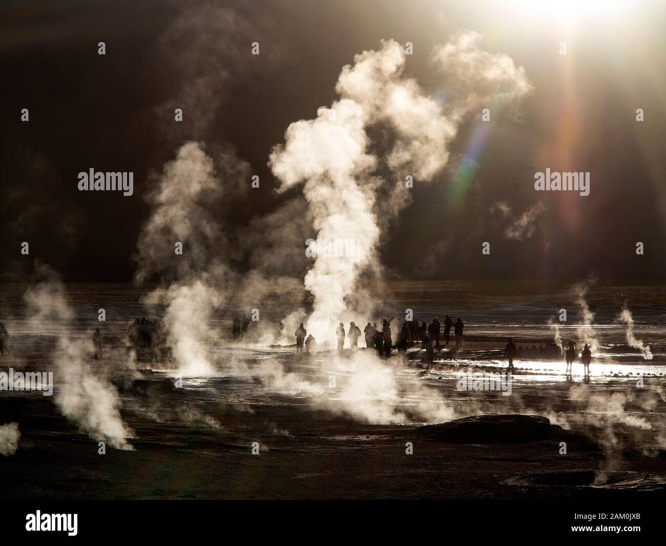 Tourists visiting the famous Geiser del Tatio at sunrise, Atacama ...