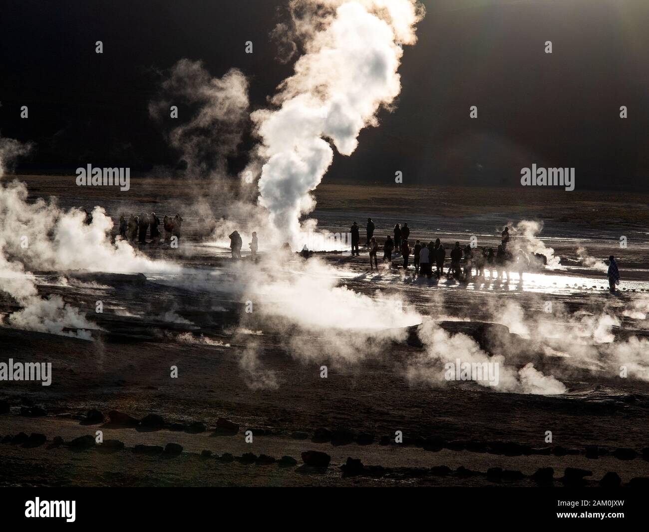 Tourists visiting the famous Geiser del Tatio at sunrise, Atacama ...