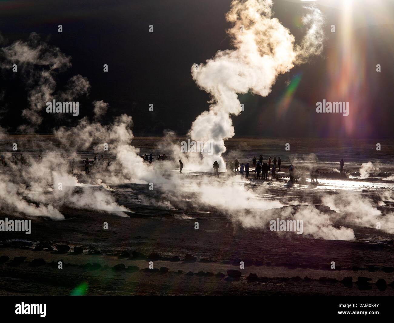 Tourists visiting the famous Geiser del Tatio at sunrise, Atacama ...