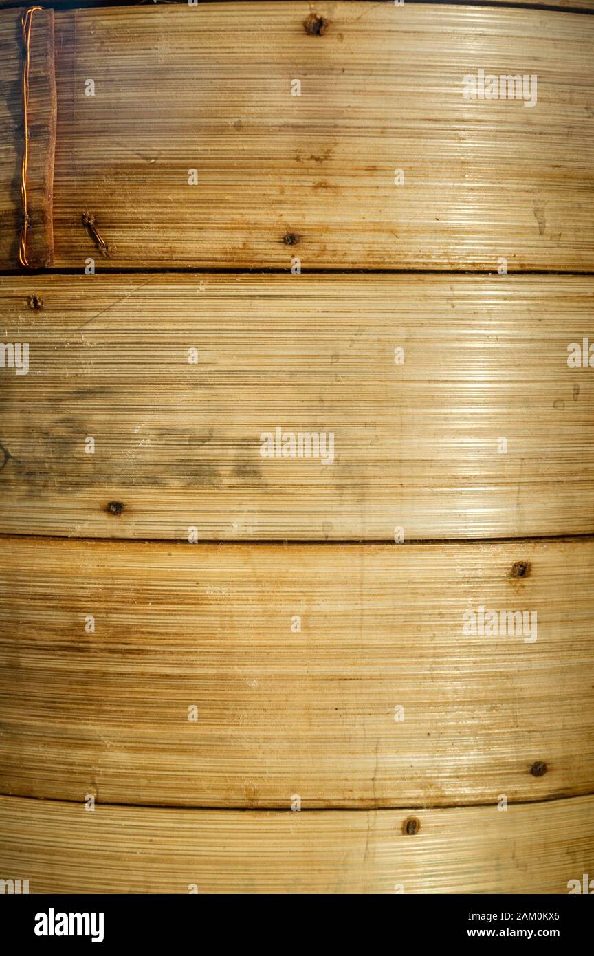 Closeup sideview detail of four round bamboo steamer pots stacked on ...