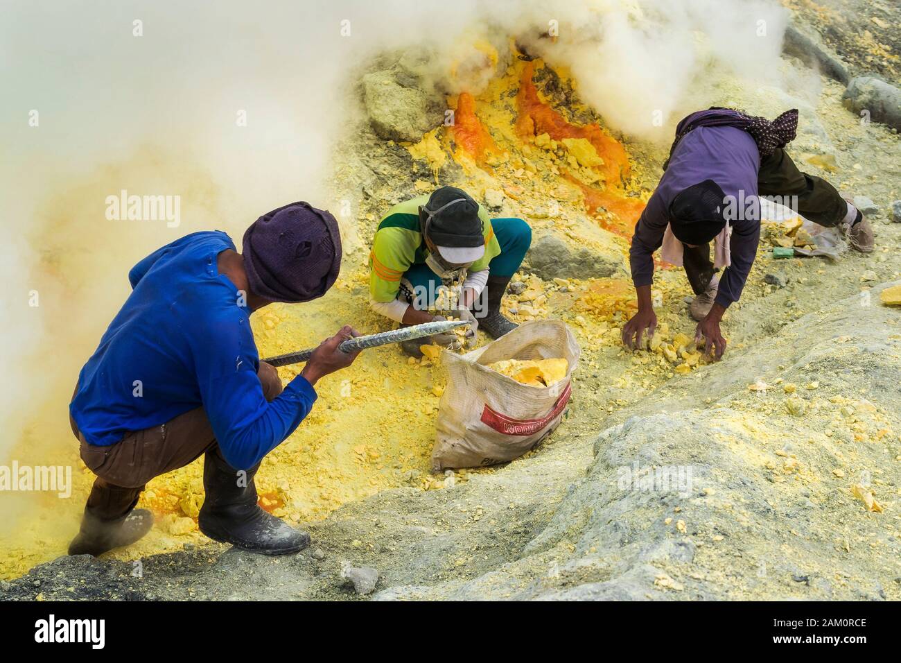 Sulphur miners extracting sulphur at the crater of Kawah Ijen volcano ...