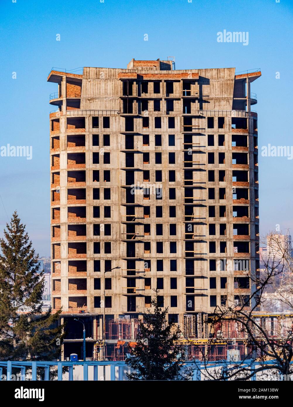 Concrete high-rise building under construction on blue sky background ...