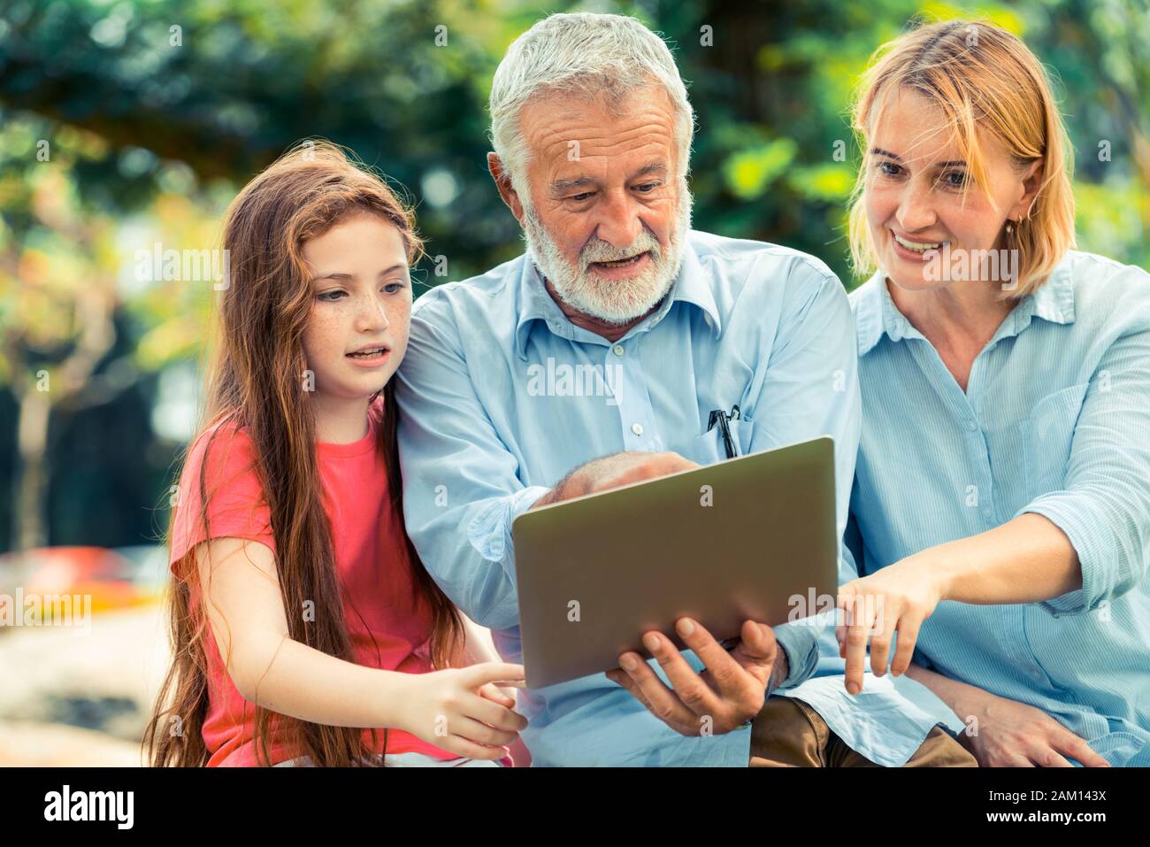 Happy family using laptop computer together in the garden park in ...