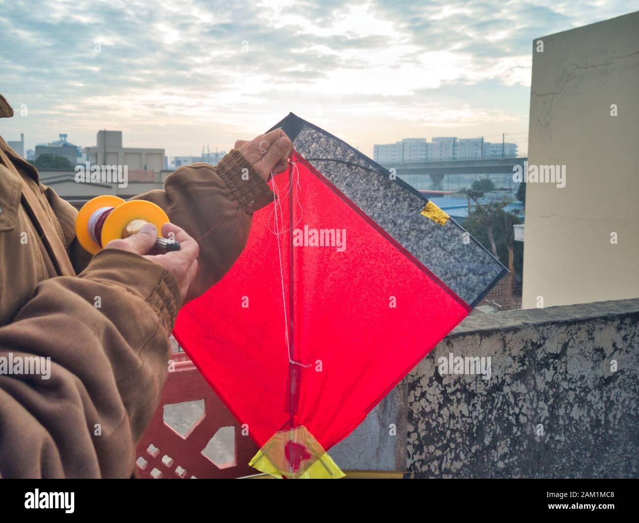 Man holding a reel of thread, charkhi, to fly kites Stock Photo - Alamy