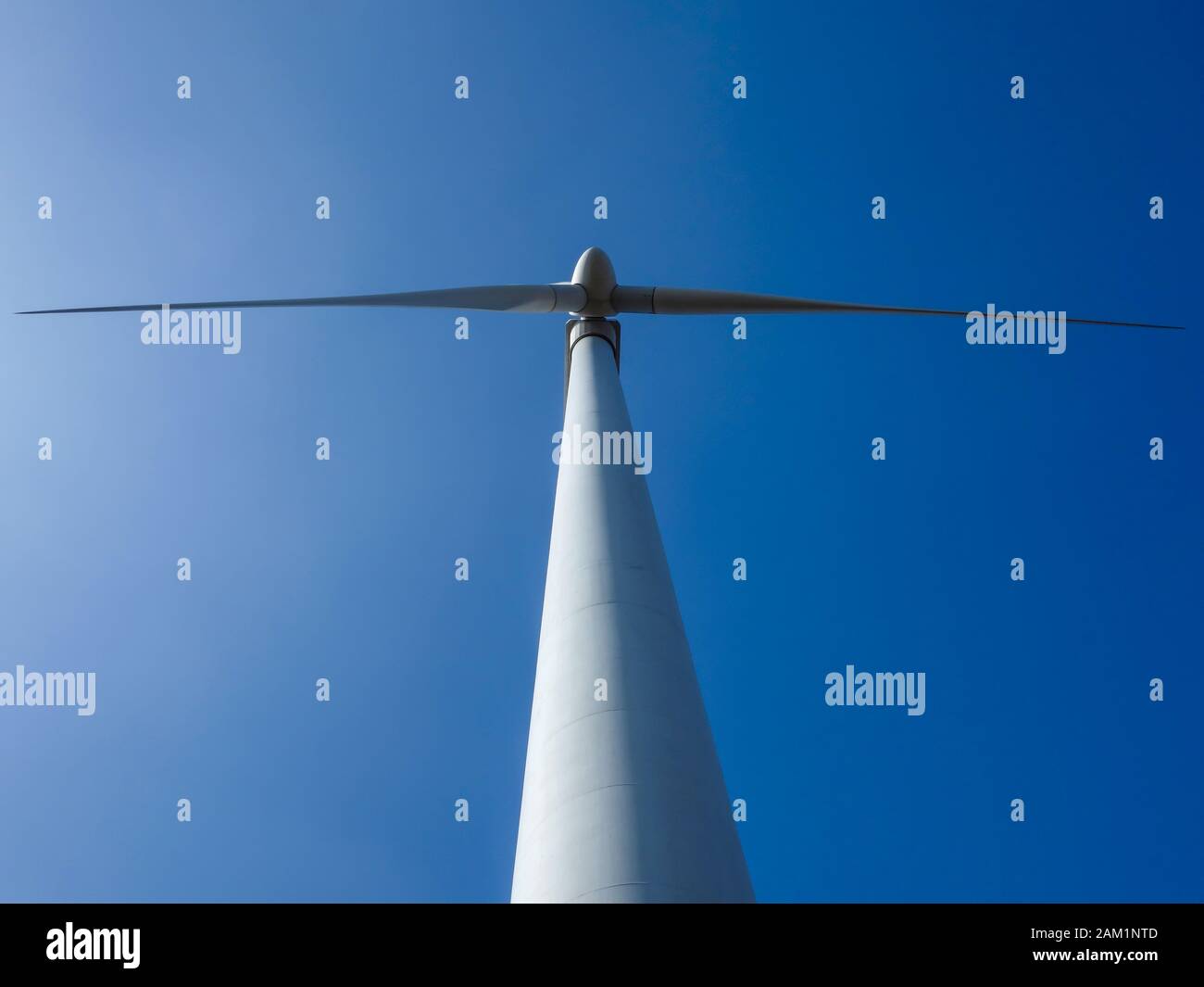 Wind turbine bottom view under cloudless clear blue sky with copy space ...