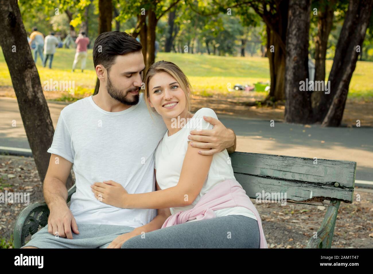 Teen couples love each other by hugging on the seat in a public garden ...