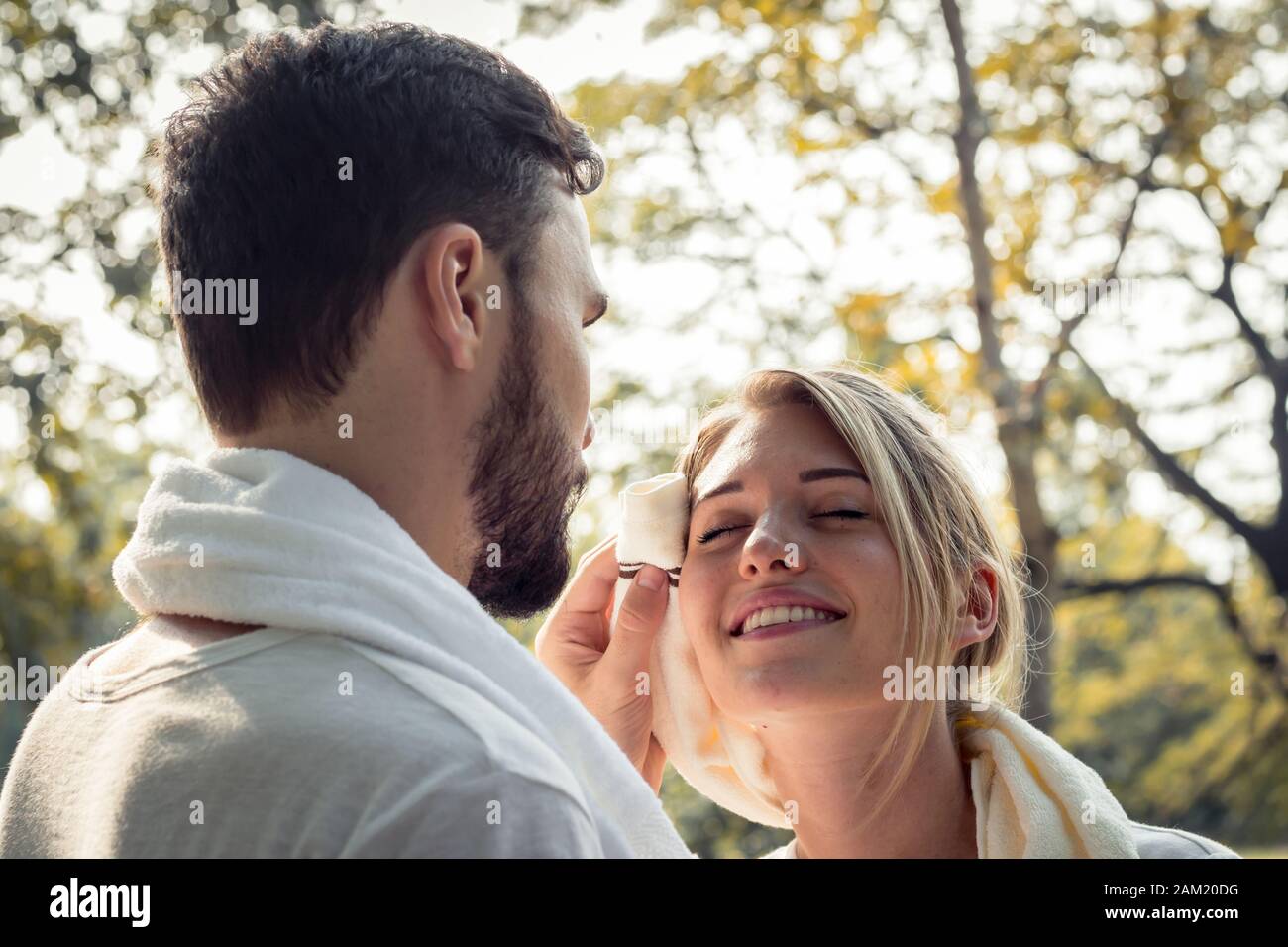 Young man wiped the sweat for his girlfriend after exercising together ...