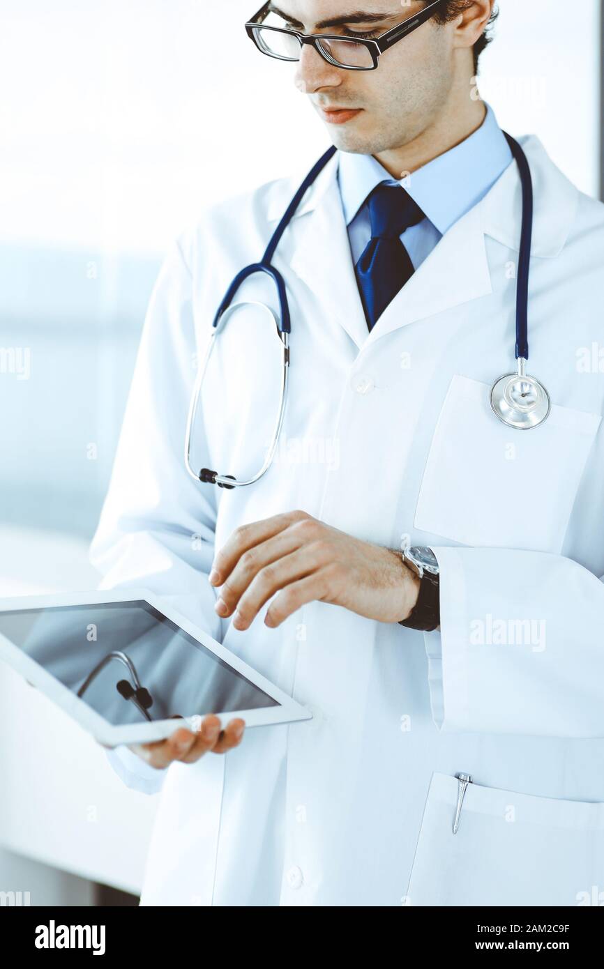Doctor man using tablet computer for network research or virtual ...