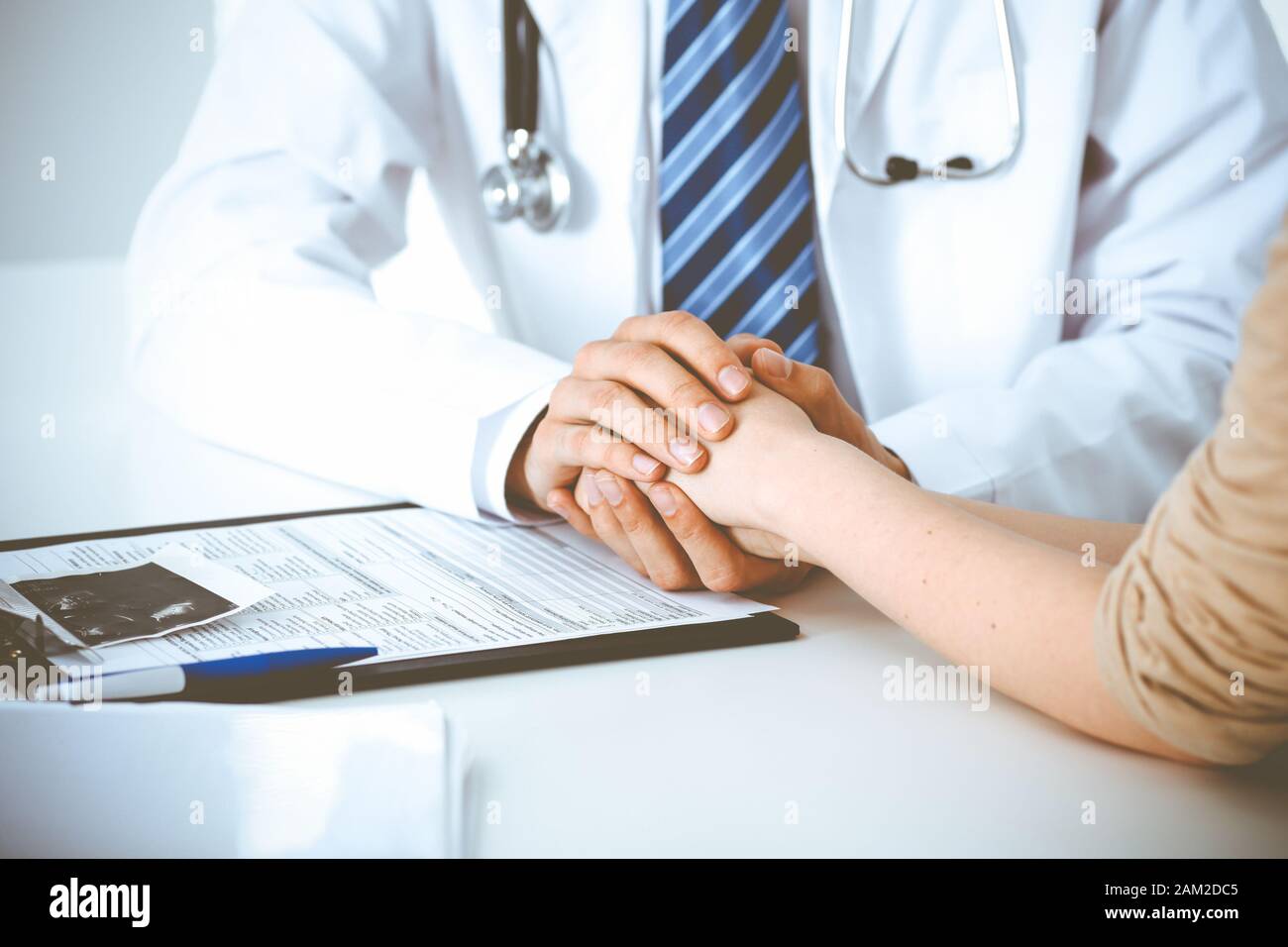 Hand of doctor reassuring her female patient. Concepts of medical ...