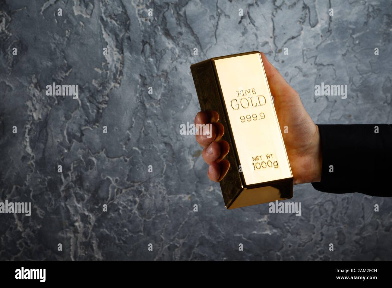 Male hand with a gold bar Stock Photo - Alamy