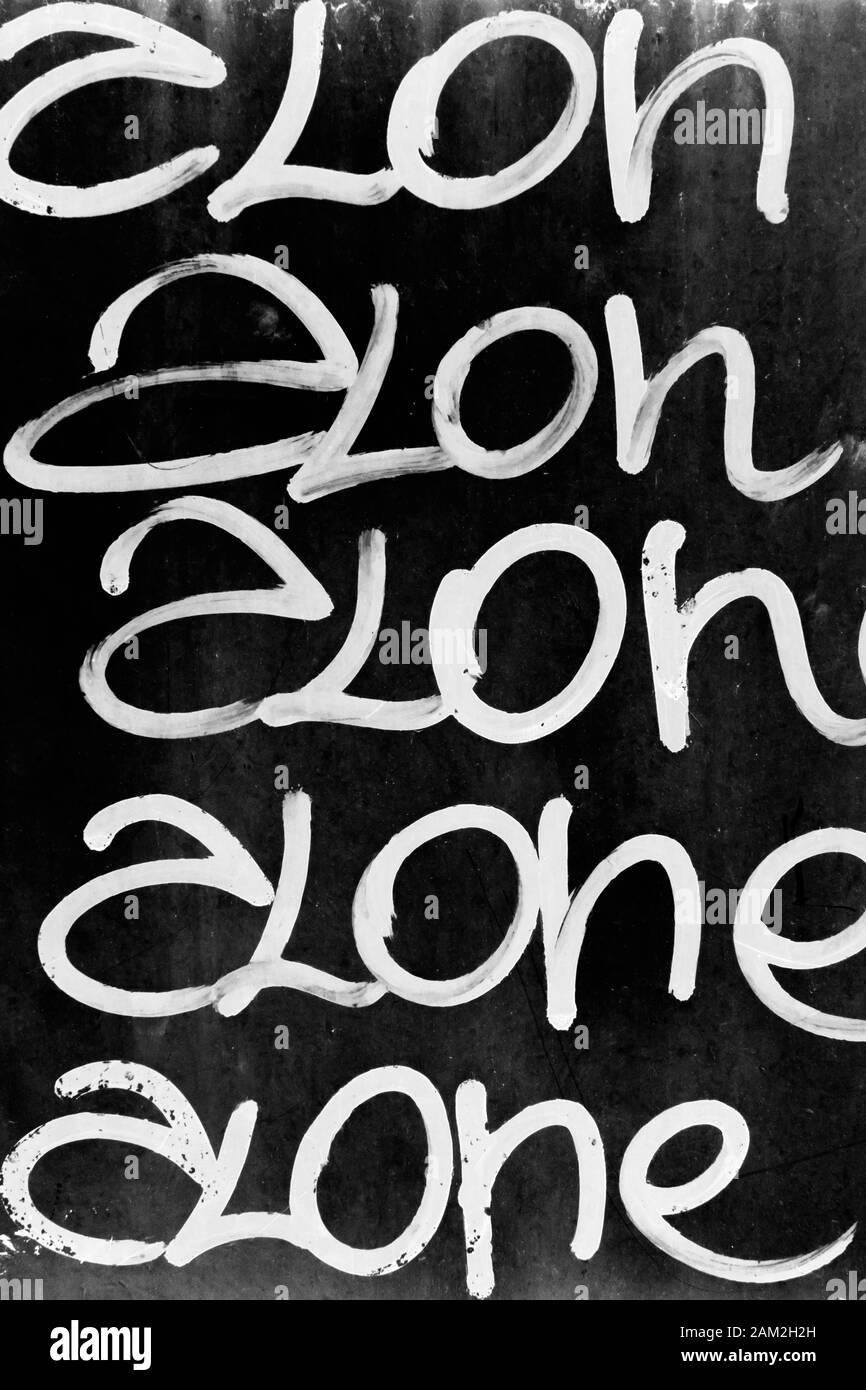 Word "alone" written on black grungy wall. It can be used as a poster ...