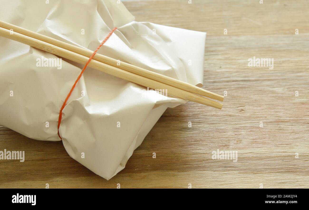 ready meal in paper packing by rubber band and wooden chopsticks Stock ...