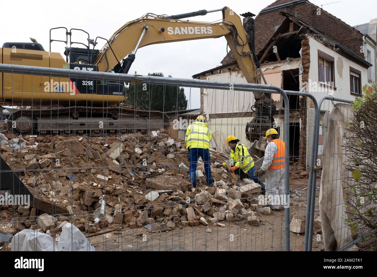 Workmen and hydraulic grab machine on demolition site in abandoned coal ...