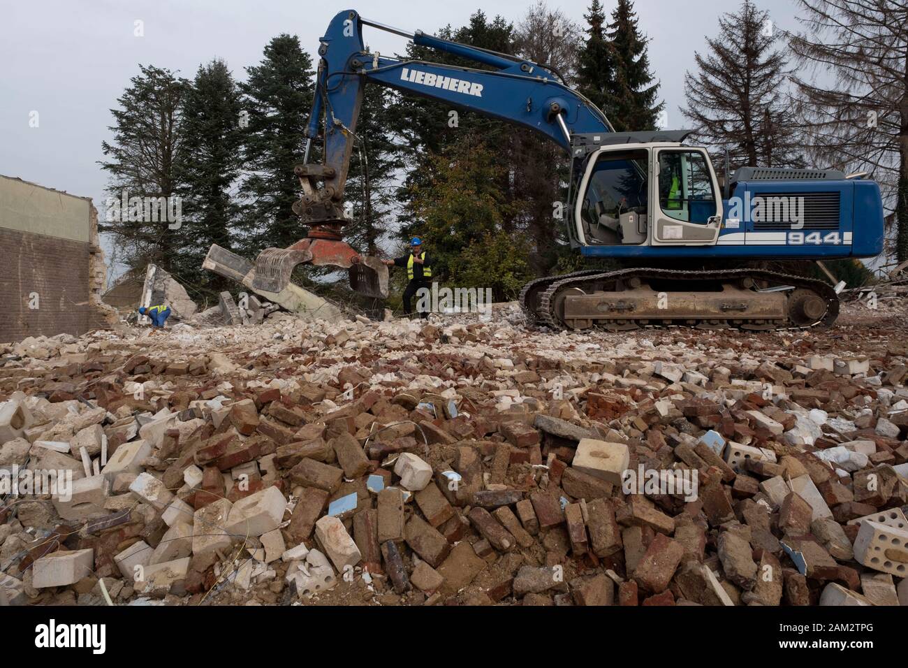 Workman giving thumbs up beside hydraulic grab machine on demolition ...