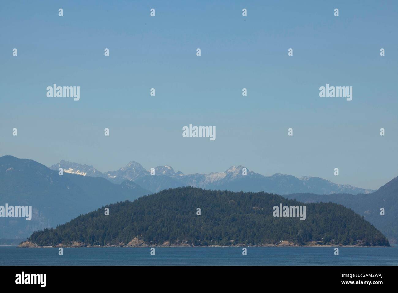 Mountains seen across calm sea from Vancouver Island, British Columbia ...