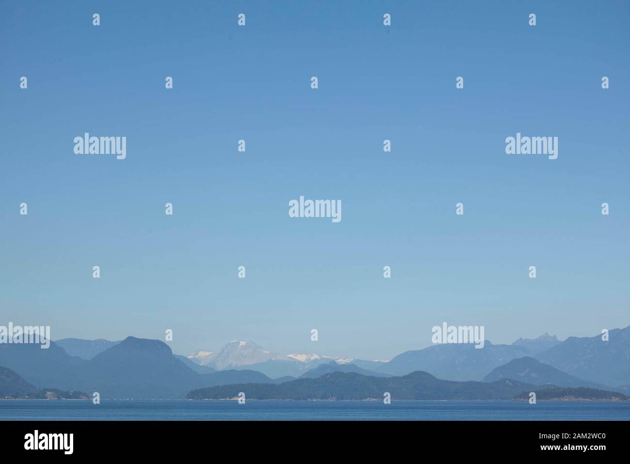 Mountains seen across calm sea from Vancouver Island, British Columbia ...