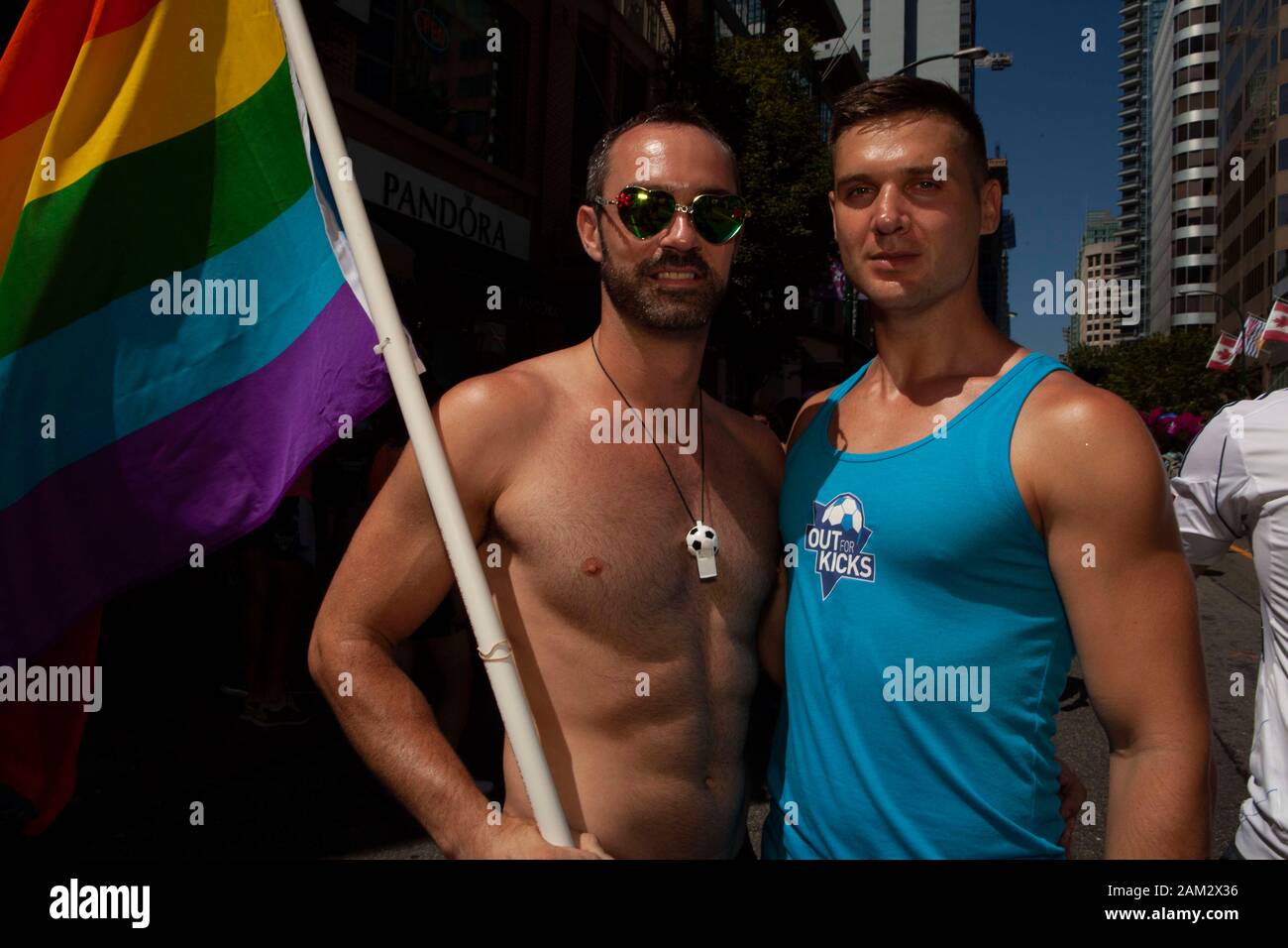 Friends participating in Pride parade posing with rainbow flag on ...