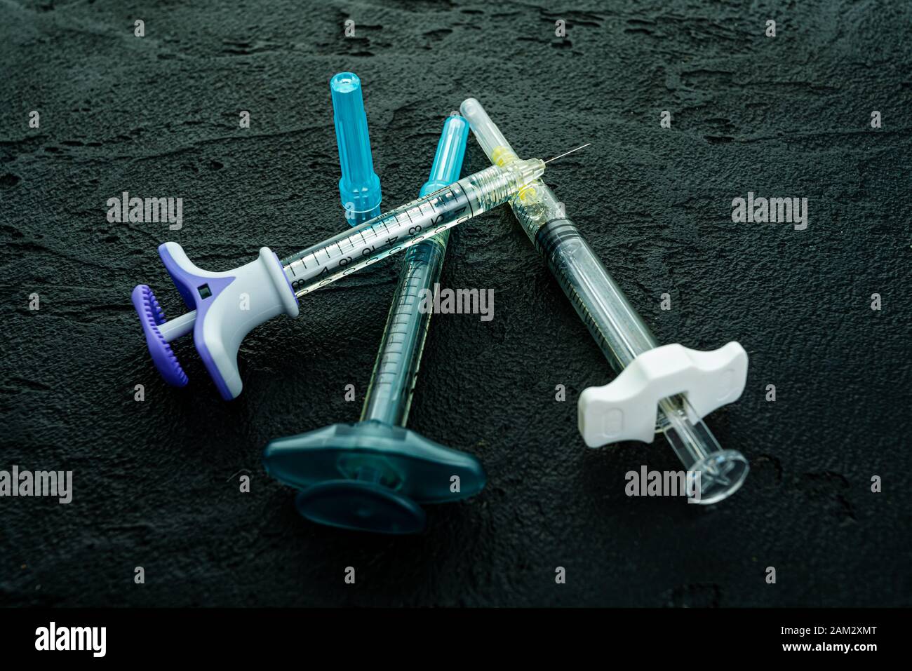 cosmetology injections. Plastic syringe on black background. Medical ...