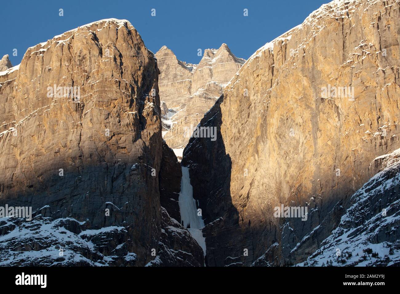 Sun falling on rockface and top of mountain range, Jasper National Park ...