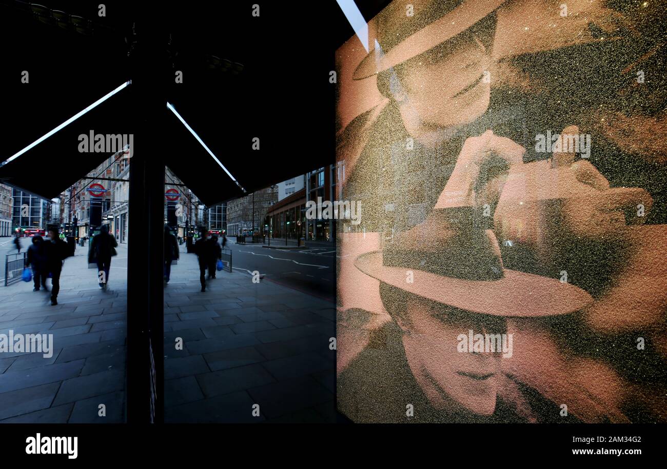Pedestrians and traffic are reflected in a shop window display of a ...