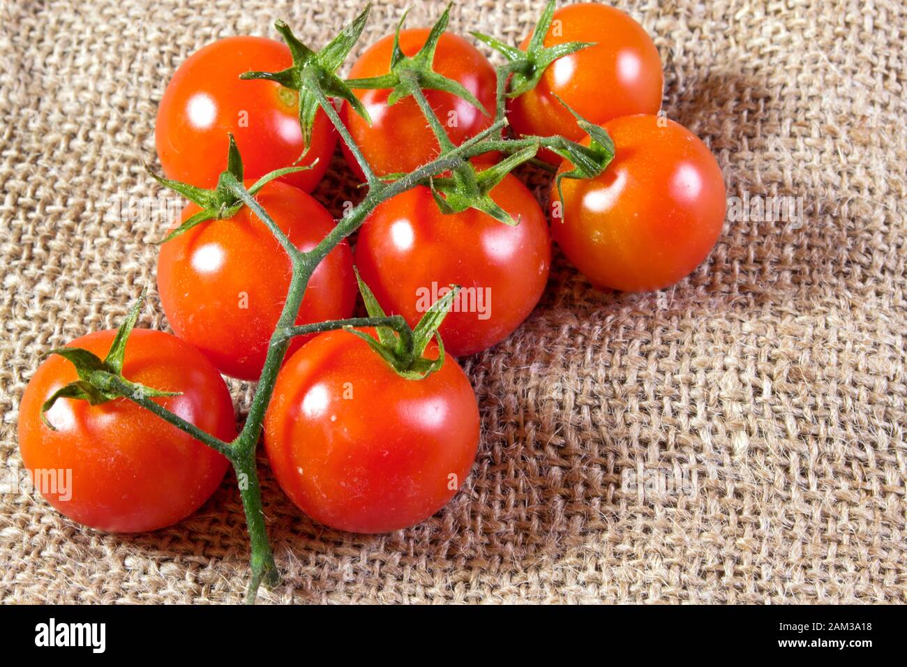 Italian food: few tomatoes on jute Stock Photo - Alamy
