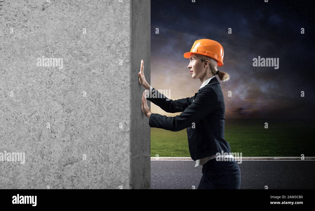 Beautiful woman architect pushing concrete wall Stock Photo - Alamy