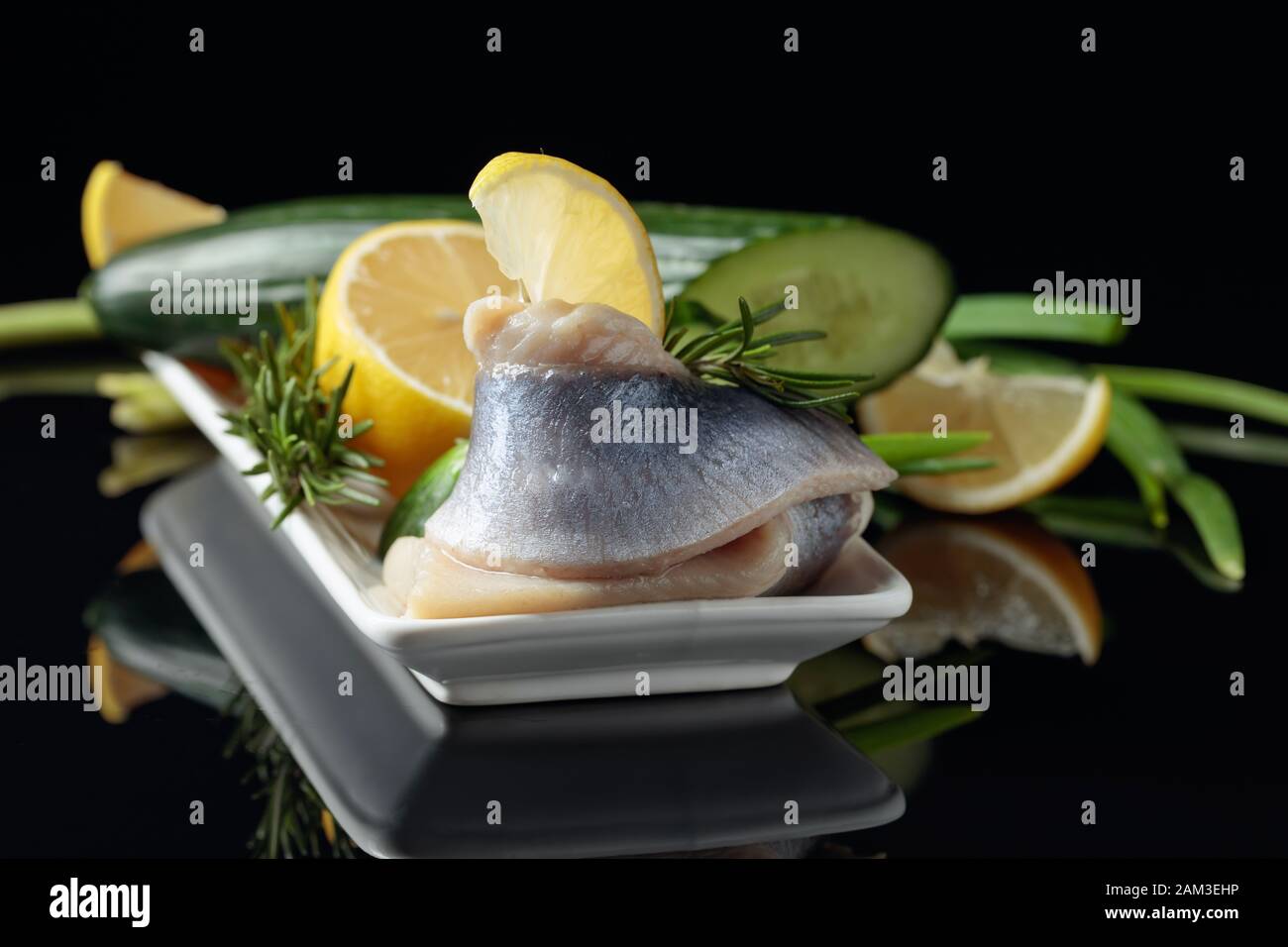 Atlantic herring with lemon, green cucumber, onion and rosemary on a ...