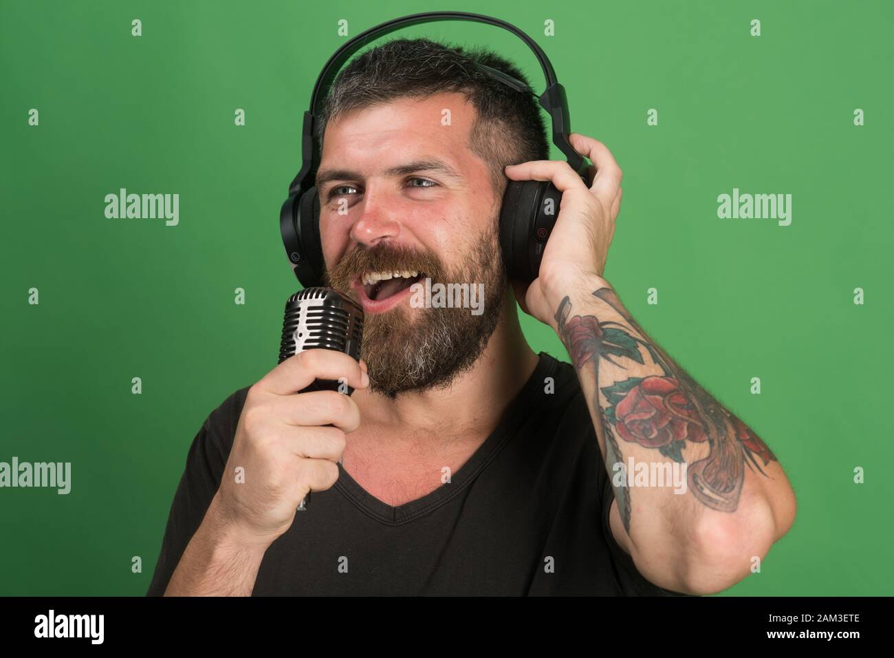 Singer with beard and smiling face enjoys music. Dj with beard wears ...