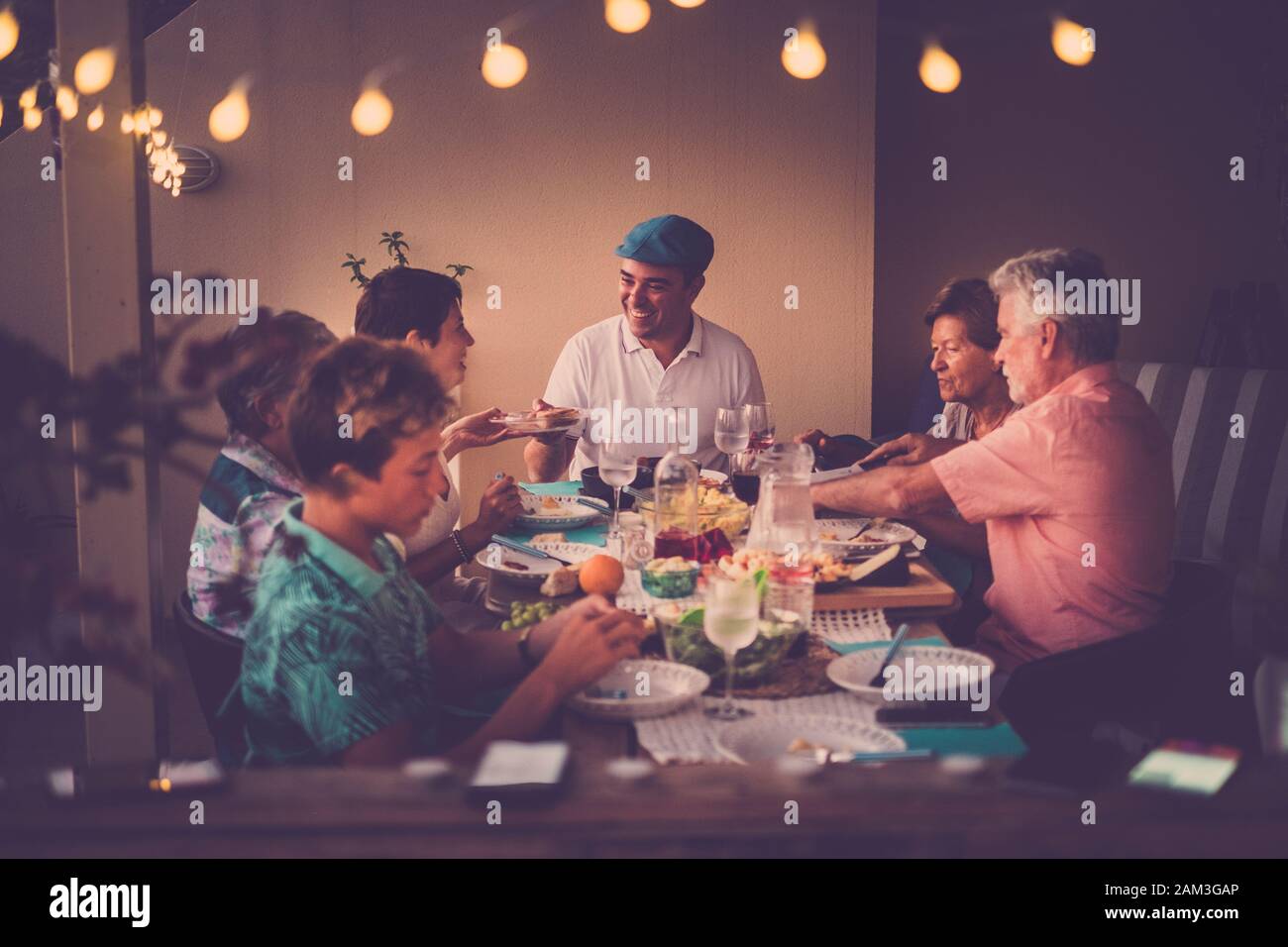 Happy and friendly people having dinner together at home or restaurant ...