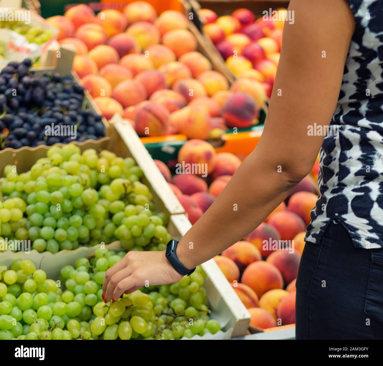 Woman choosing fruits in a grocery store Stock Photo - Alamy