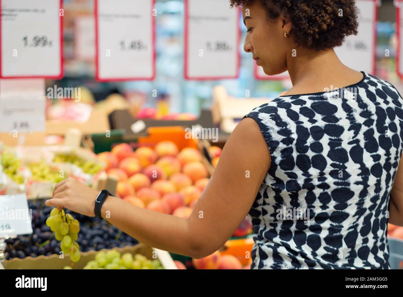 Woman choosing fruits in a grocery store Stock Photo - Alamy