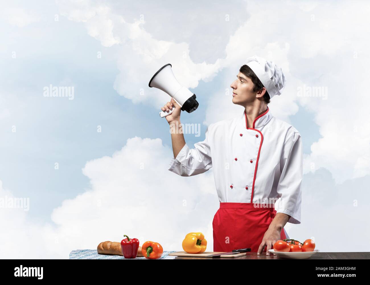 Young chef standing with megaphone in hand Stock Photo - Alamy