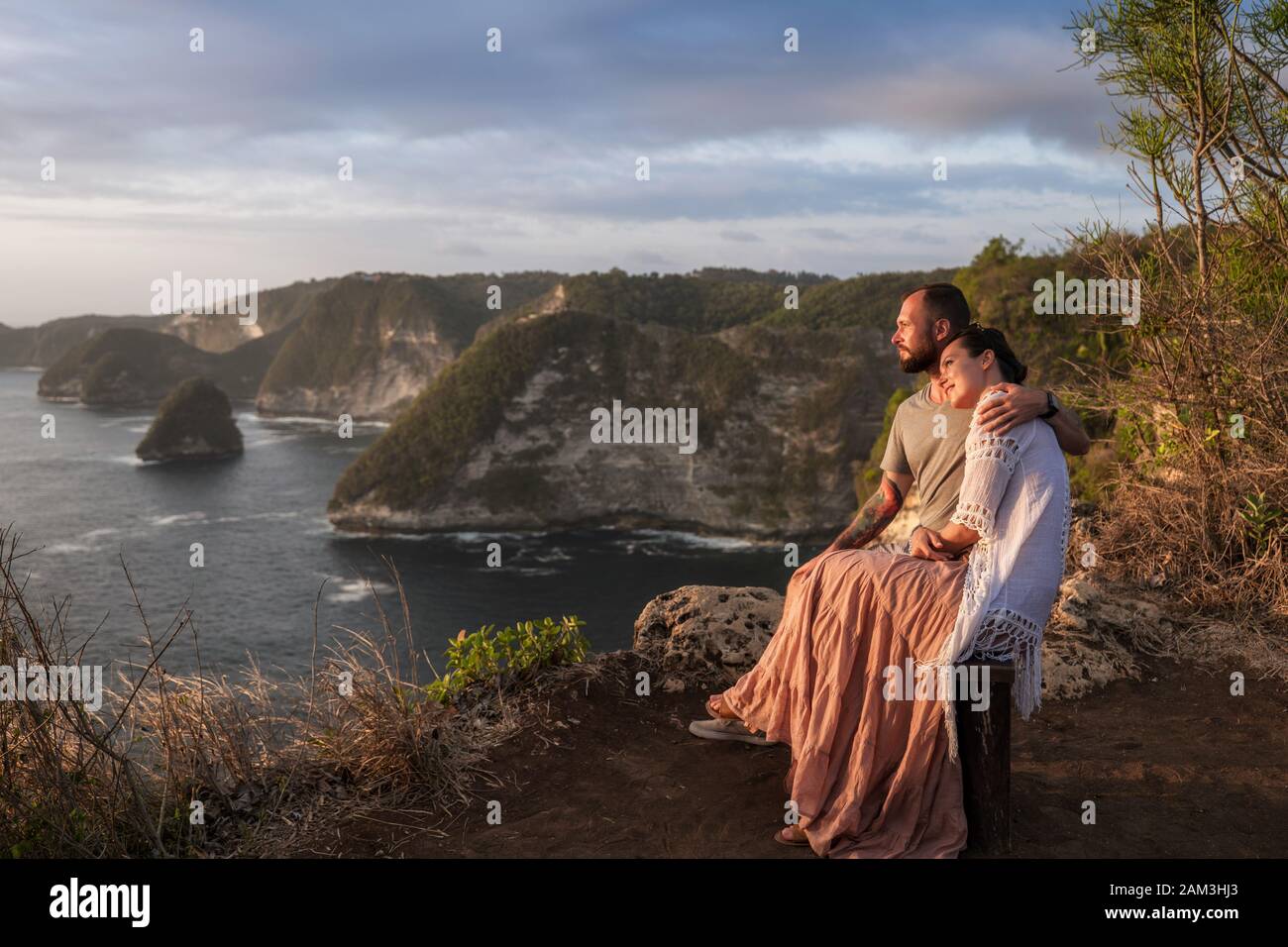 Couple enjoying view from Banah Cliff of Nusa Penida island, Indonesia ...