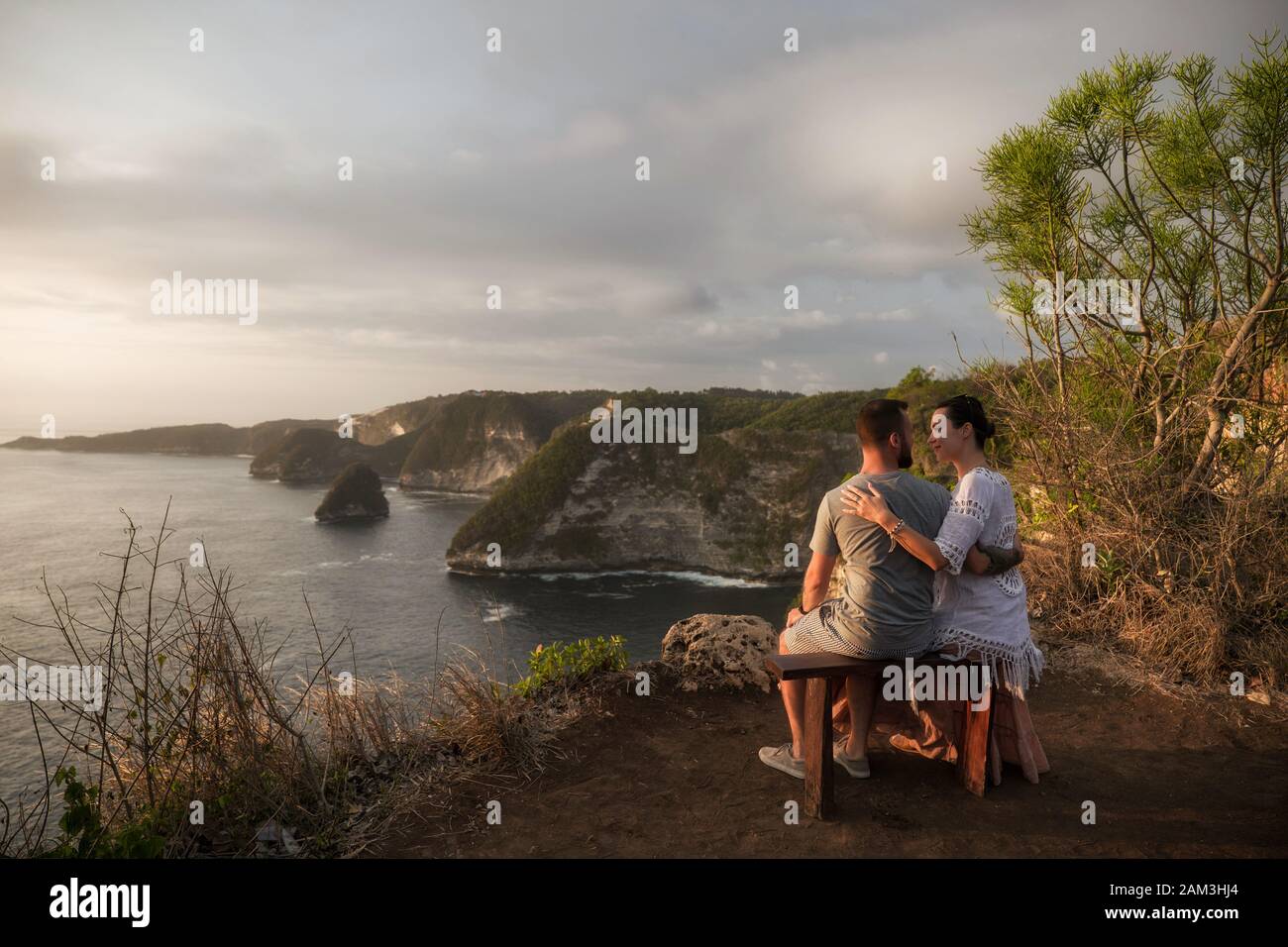 Couple enjoying view from Banah Cliff of Nusa Penida island, Indonesia ...