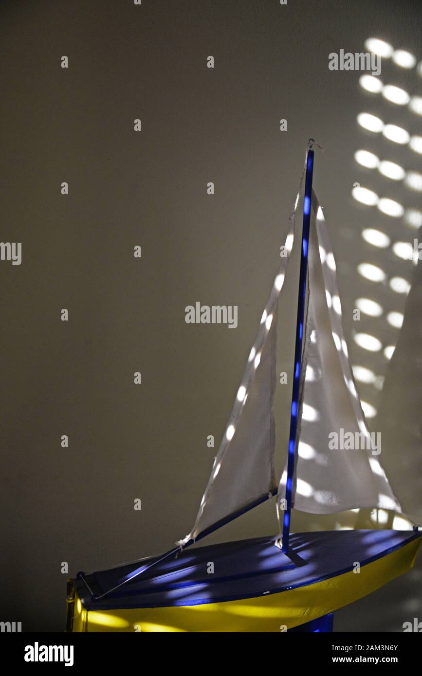 Scale model of a wooden sailing boat illuminated by light coming ...