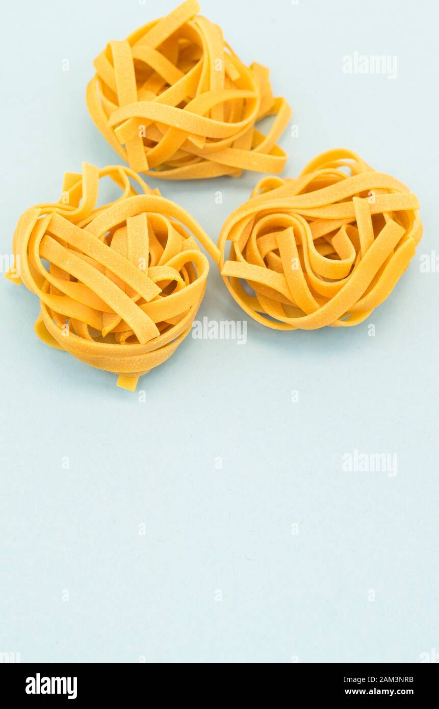 italian tagliatelle nest on a light blue background - natural food ...