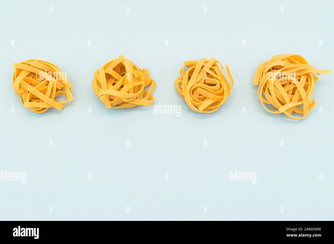italian tagliatelle nest on a light blue background - natural food ...