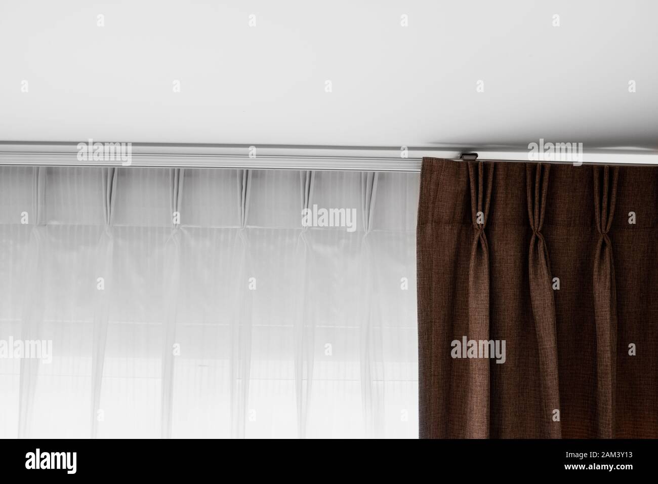 Brown curtains and white tulle on a rail with a white ceiling. Curtain ...