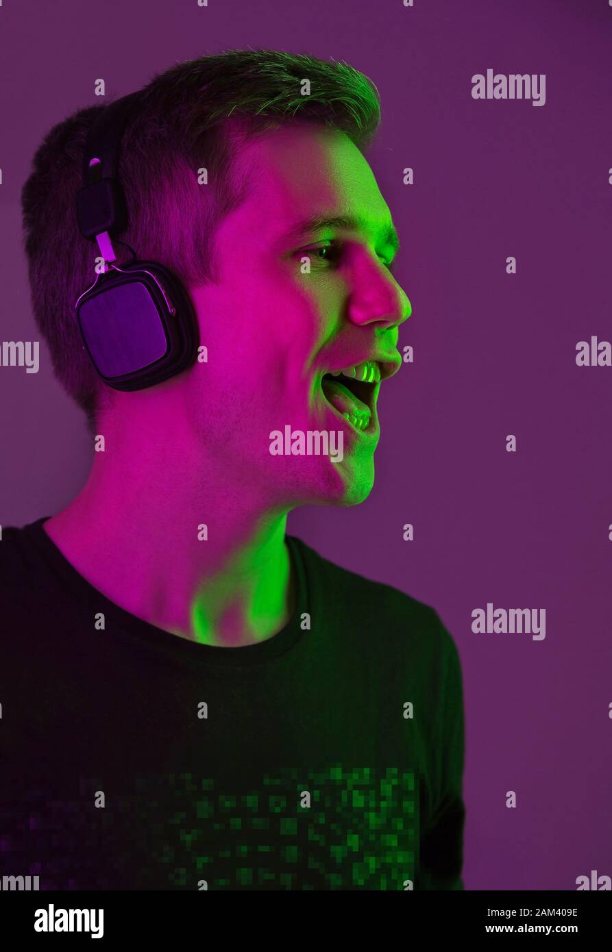 Listen to music, singing. Caucasian man's portrait isolated on purple ...