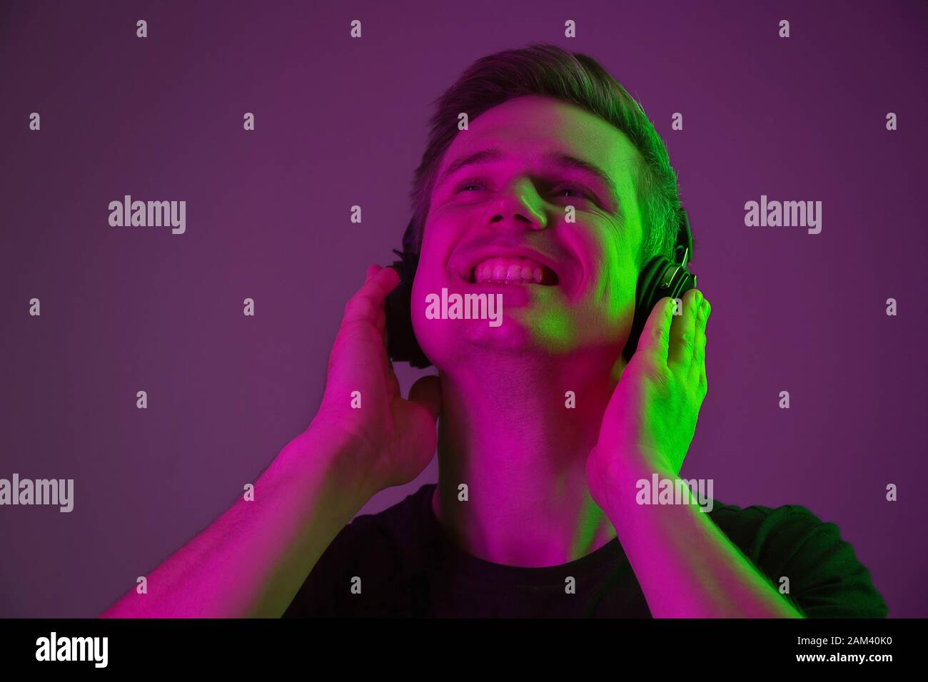 Listen to music, singing. Caucasian man's portrait isolated on purple ...