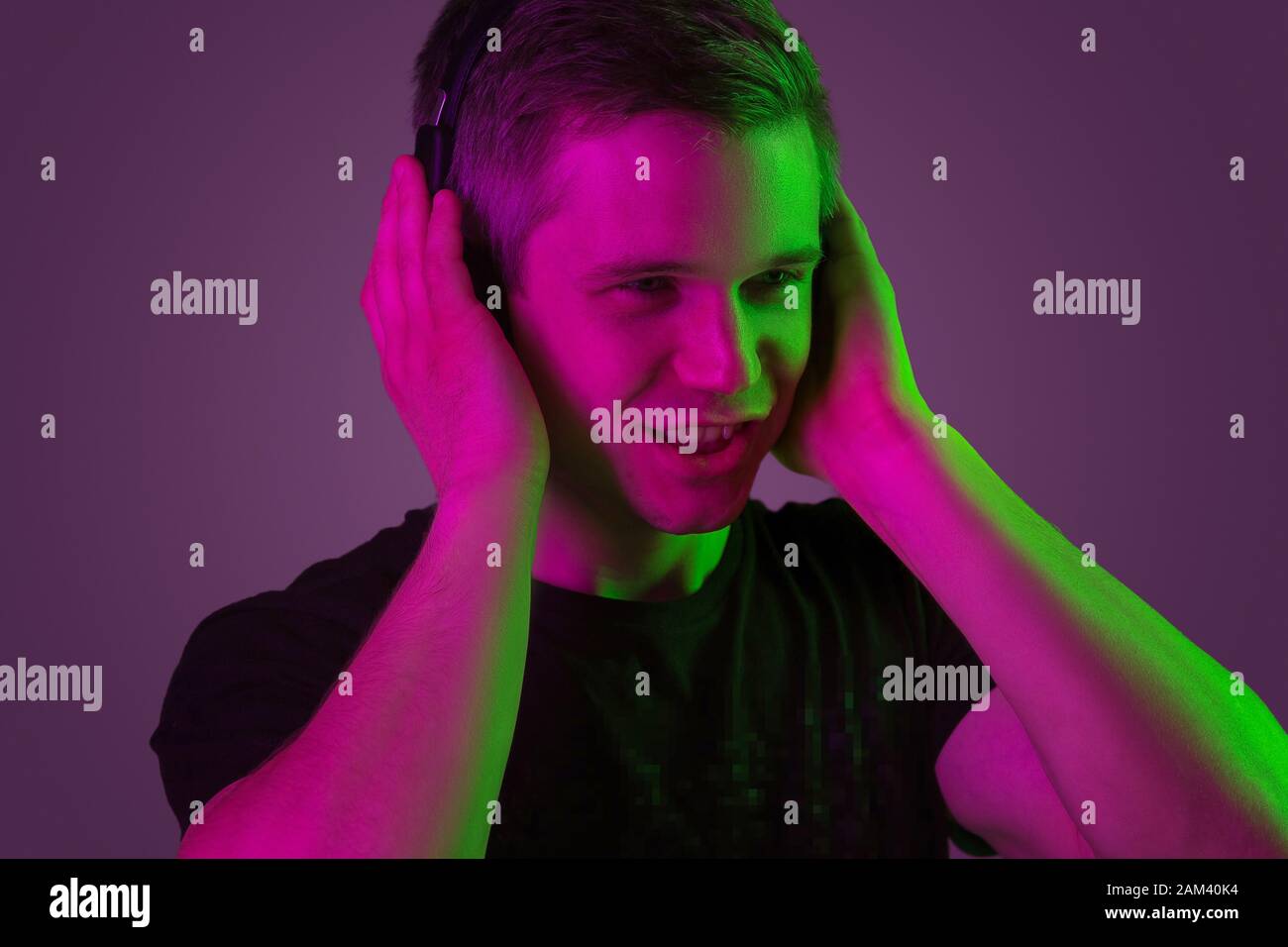 Listen to music, singing. Caucasian man's portrait isolated on purple ...