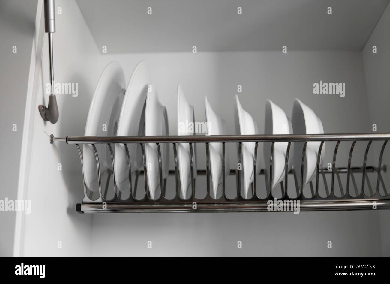 Dish drying metal rack with big nice white clean plates. Traditional ...